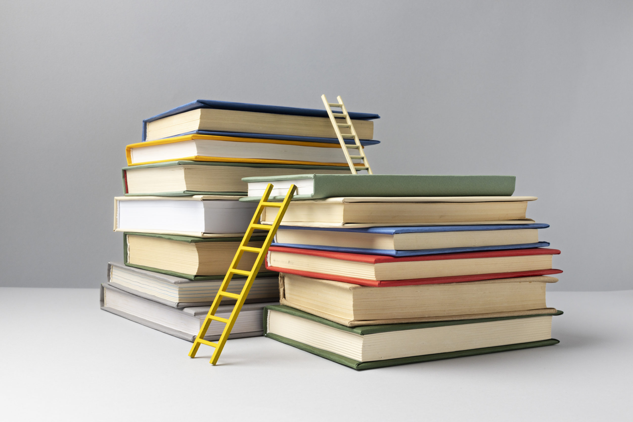 front-view-stacked-books-ladders-education-day | AJYAL